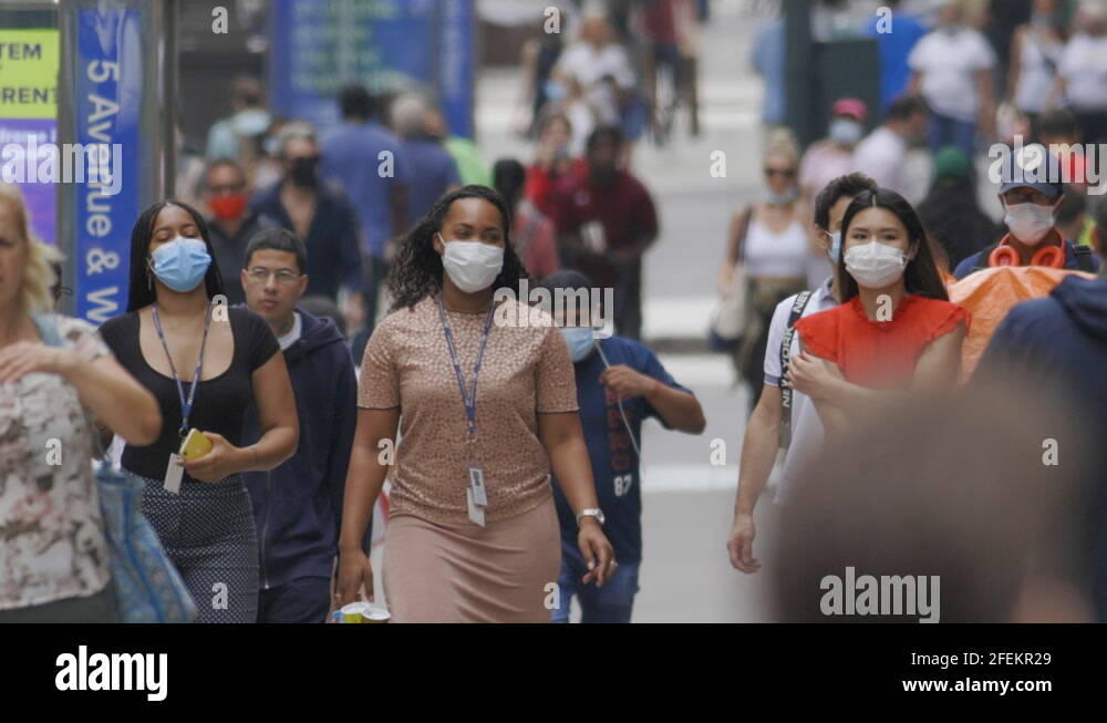 Crowd of people walking street wearing mask masks during coronavirus ...