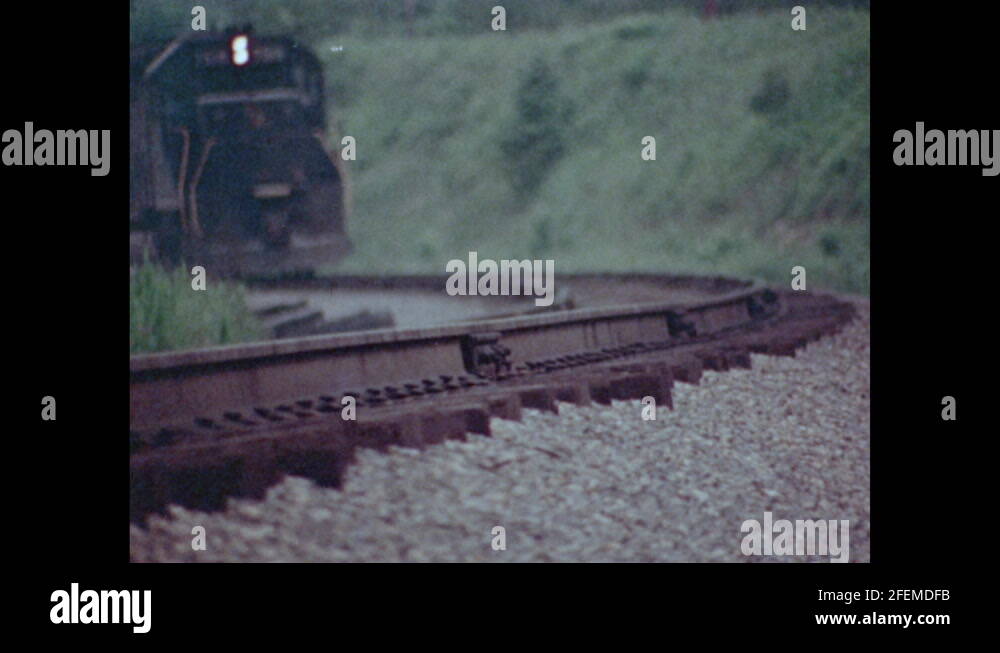 1970s: Low angle of train tracks, train drives past camera. Close up of ...