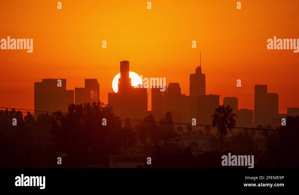 Downtown Los Angeles. Sunrise sun over city buildings silhouettes, zoom ...