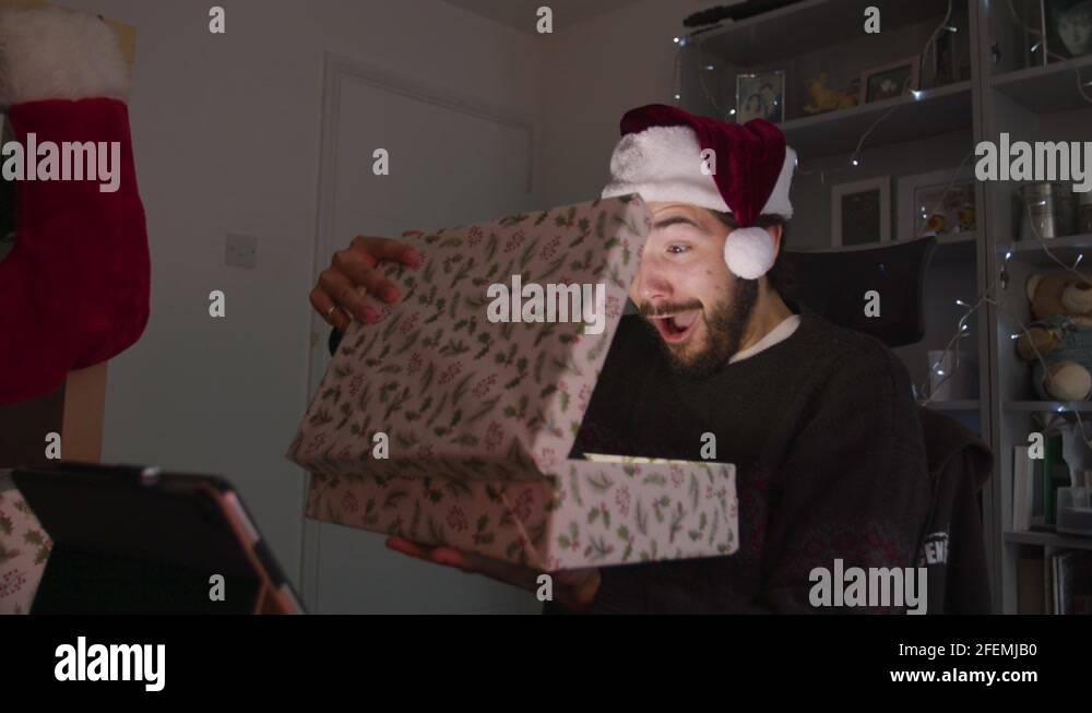 Male overly shocked opening Christmas present which lights up face ...