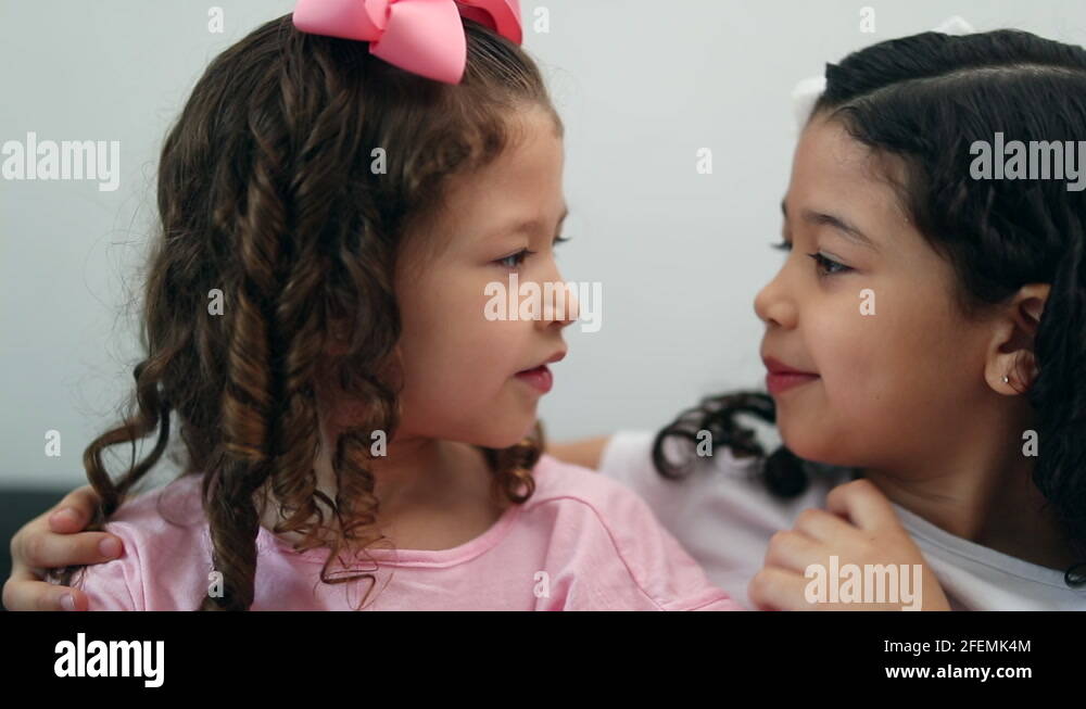 Two little sisters in conversation, small children talking to each ...