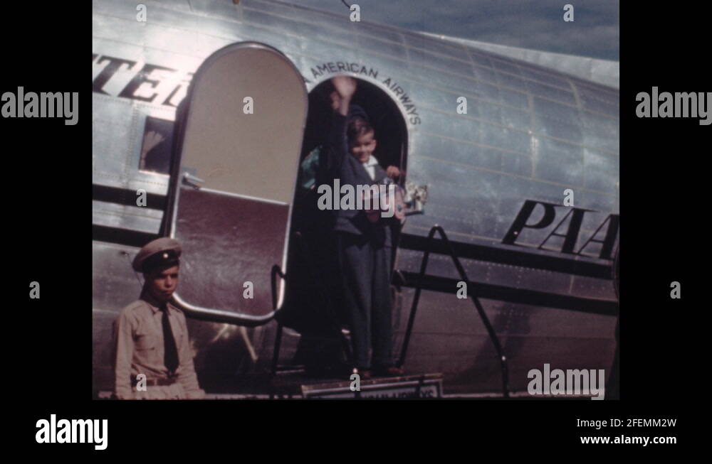 1940s: Boy walks up steps to board plane, turns around, waves goodbye ...