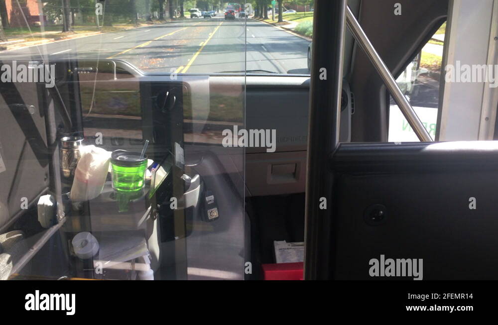 Bus driver sits behind plexiglas shield, installed for safety during ...