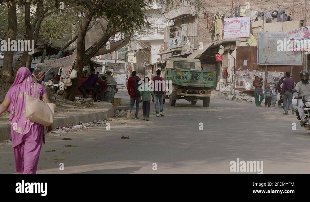 Two shots of busy dusty road with traffic in slums of New Delhi India ...
