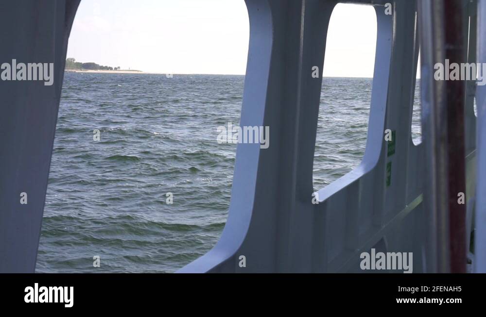 Wavy sea and distant land seen through glassless windows on sailing ...