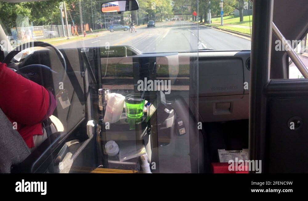 Bus driver sits behind plexiglas shield, installed for safety during ...