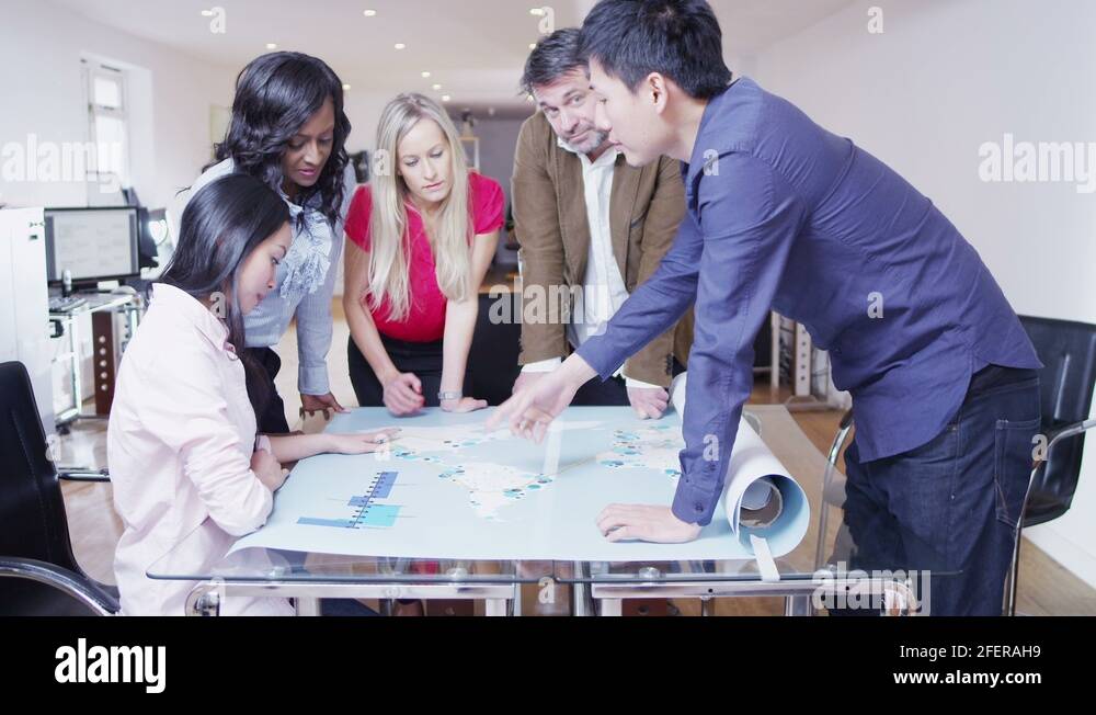 Global business team examining a map of the world Stock Video Footage ...