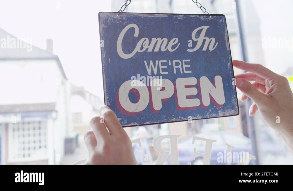 'Closed' sign is turned to 'Open' in a storefront window Stock Video ...