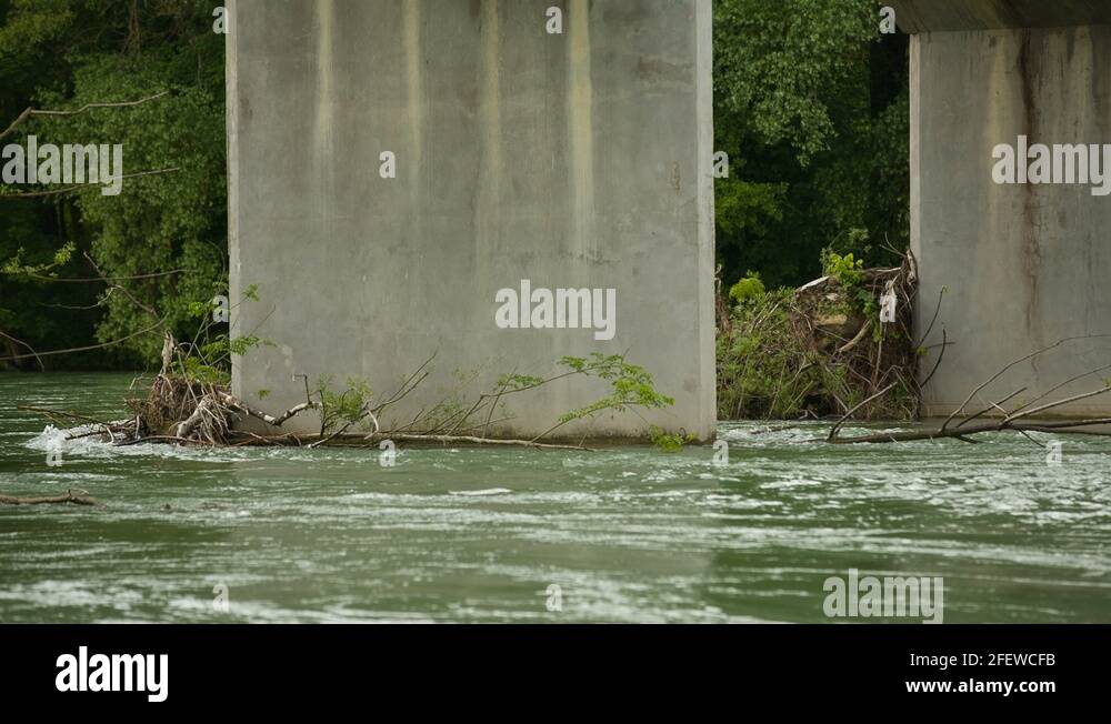 River carry trees get stuck under bridges Stock Video Footage - Alamy