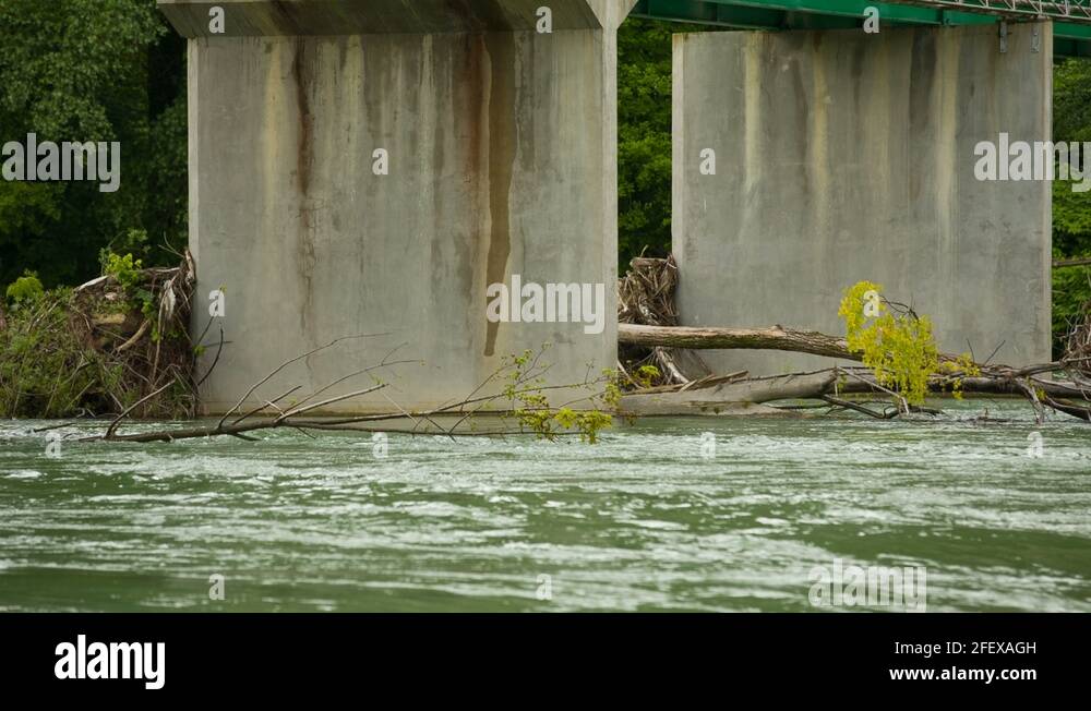 After flood of river trees stuck under bridge pillars Stock Video ...