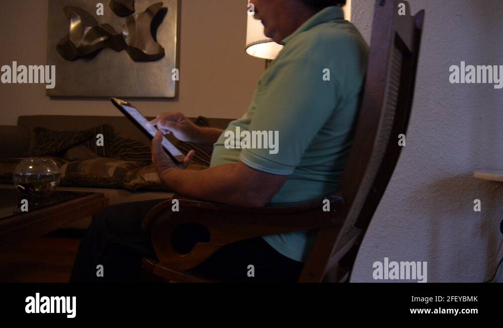 Elderly man grandfather grandpa in rocking chair in family room with ...