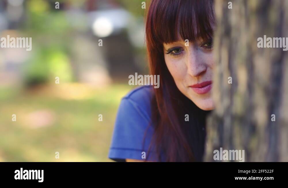 Close up of a woman flirting with the camera while sneaking around a ...