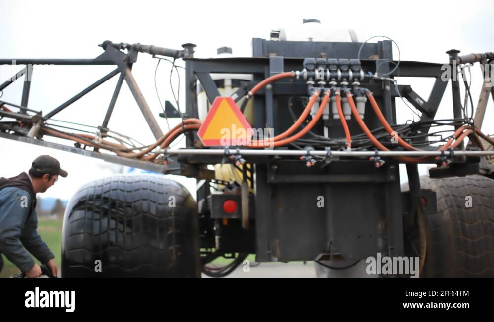 A farmer cleaning his tractor using a power washer Stock Video Footage ...