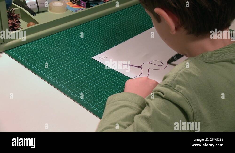 Little boy drawing, child works at his desk, school boy doing homework ...