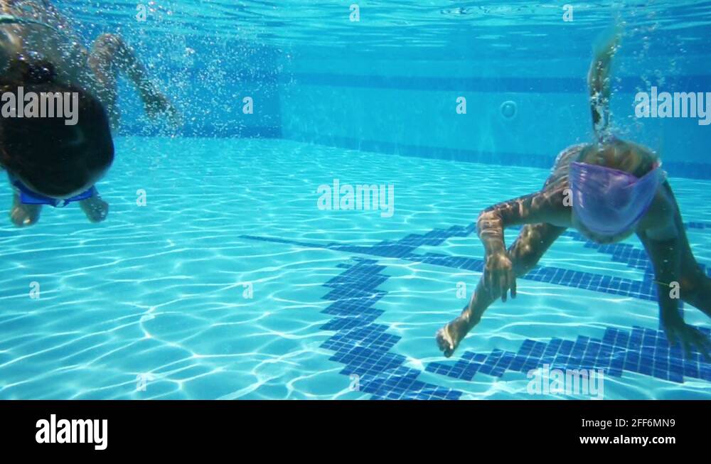 Two little girls dive and take out his hands to bottom of pool Stock ...