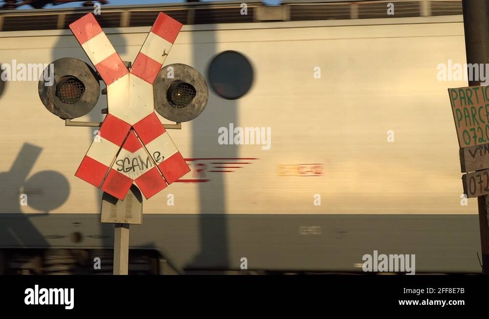 Freight train on cross at railway crossing, red flashing lights signal ...