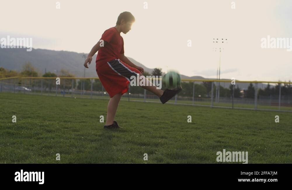 Kid practicing with soccer ball in sunshine Stock Video Footage - Alamy