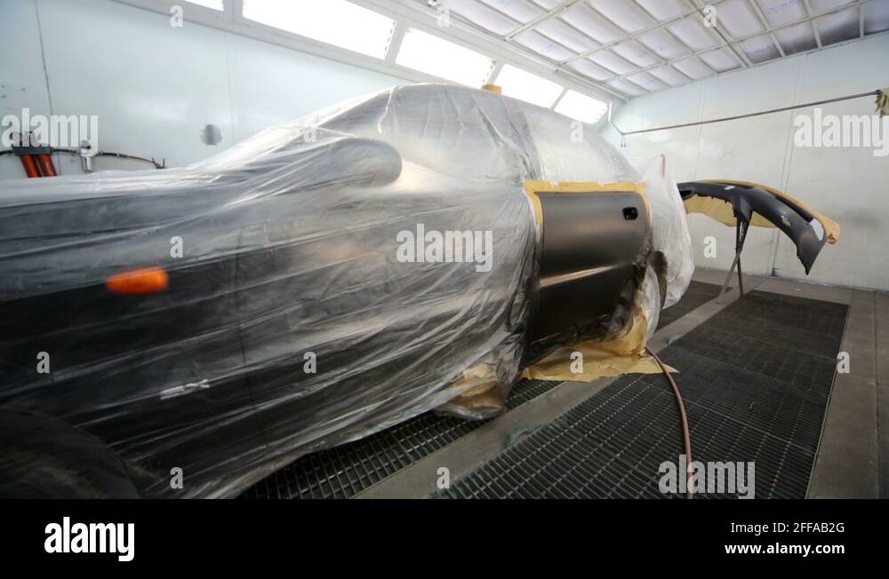 Overview of car covered by drop cloth at painting booth Stock Video ...