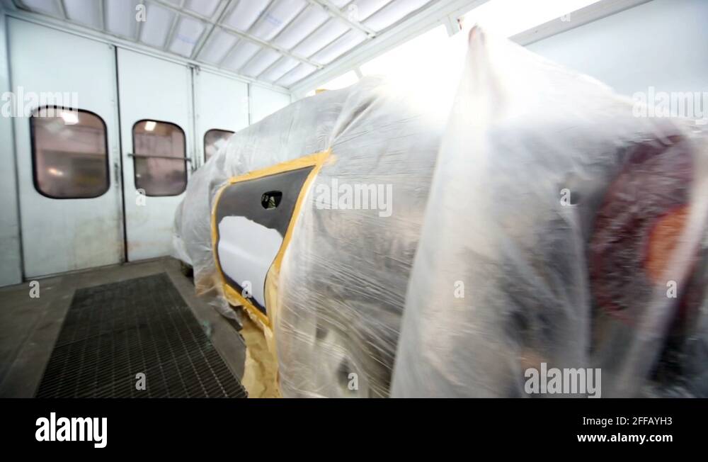 Overview of car covered by drop cloth at painting booth Stock Video ...
