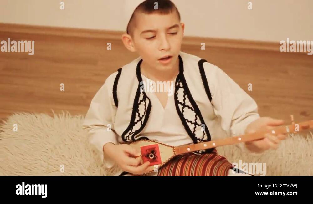 boy in traditional costume singing and playing string instrument Stock ...