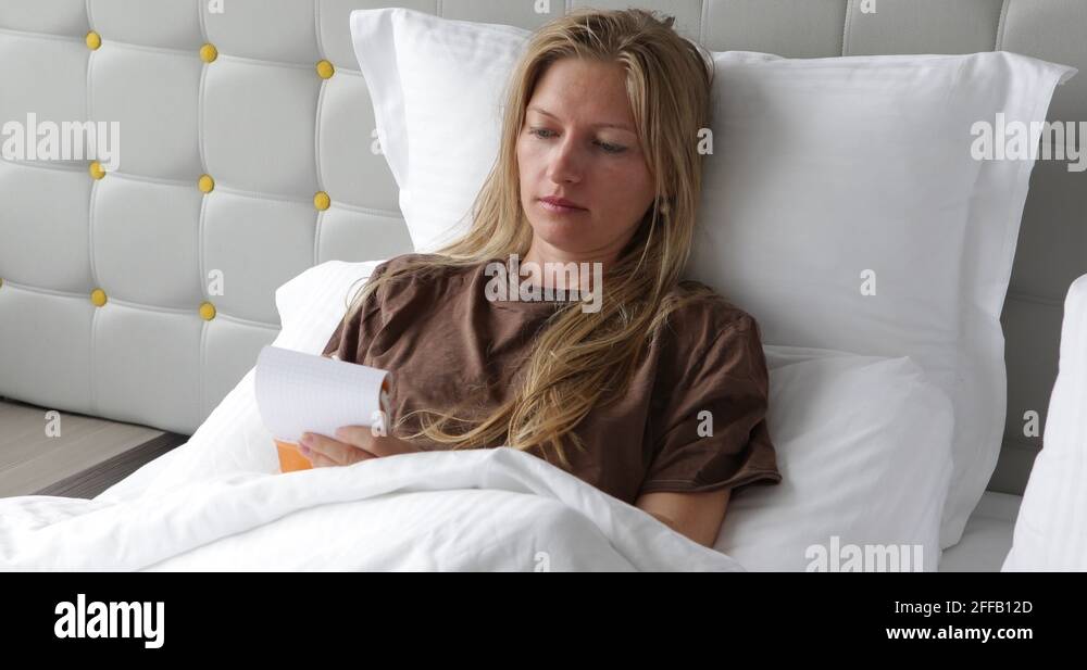 Ultra HD 4K Blonde woman write memories diary lying bed luxury house ...