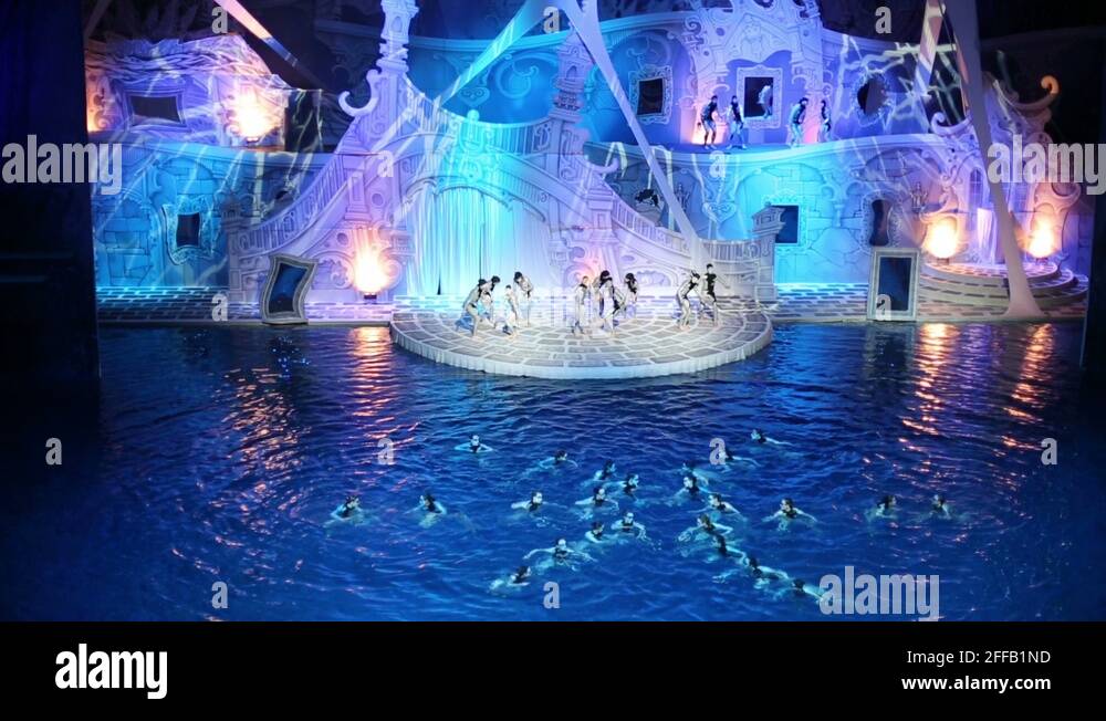 Actors dance on stage and synchronized swimmers at Swimming Pool Stock ...