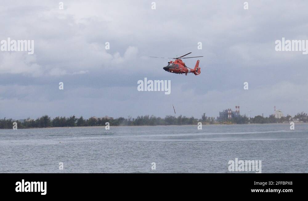 US Coast Guard rescue helicopter lift survivor with harness Stock Video ...