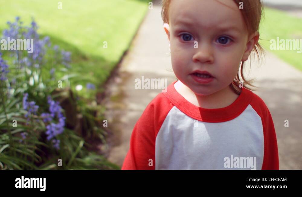 Little Boy Smells The Flowers In His Front Yard Stock Video Footage - Alamy