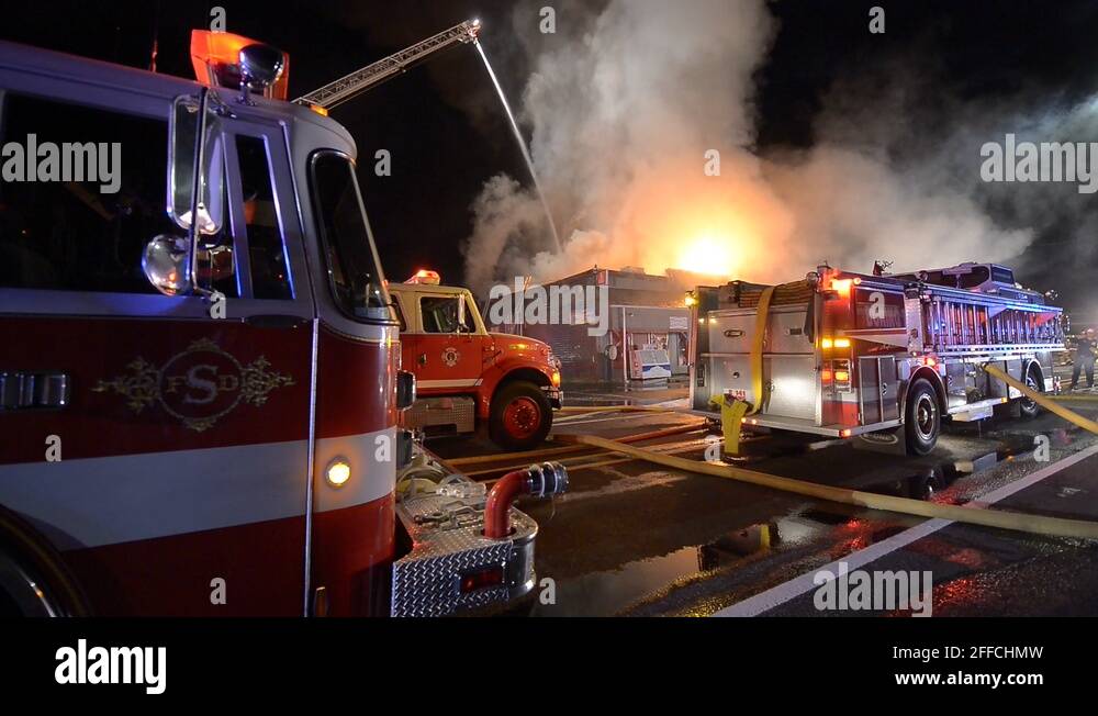 Building On Fire And Firetrucks With Emergency Lights At Night Stock ...