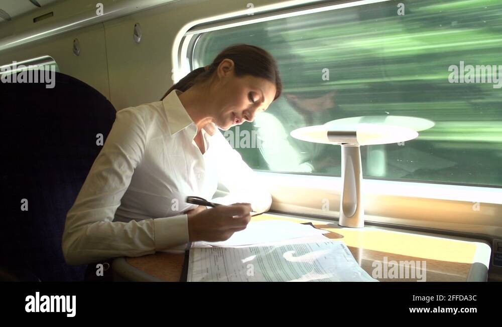 Female Commuter On Train Working On Document Stock Video Footage - Alamy