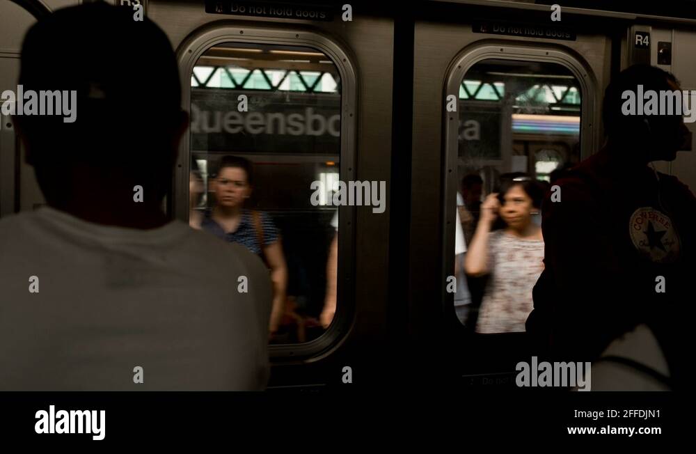 commuters crowd of people enter MTA subway train in Queens in New York ...