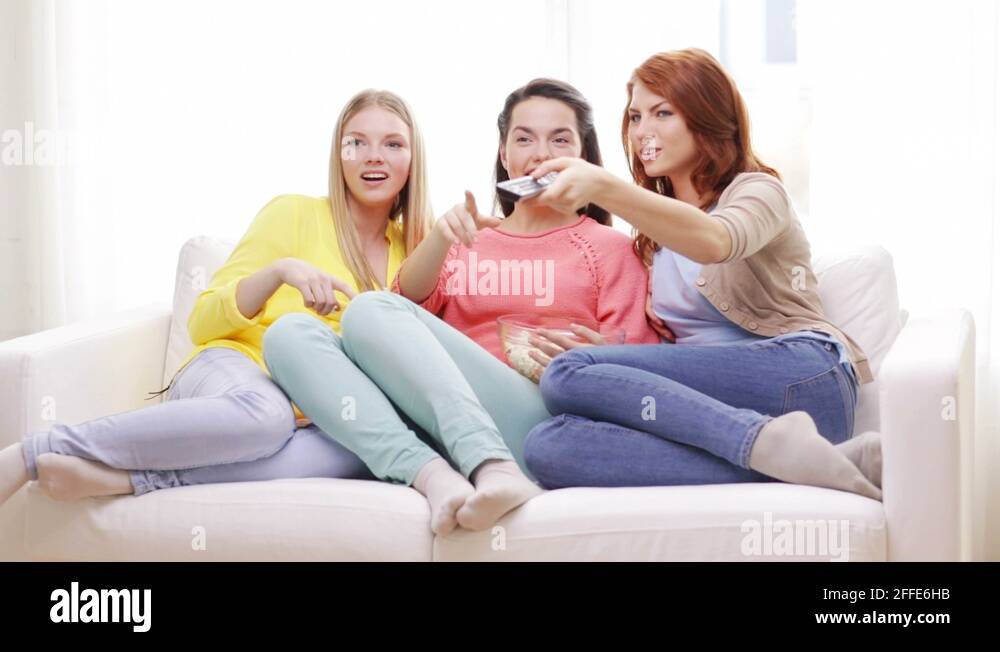 three smiling teenage girls watching tv at home Stock Video Footage - Alamy