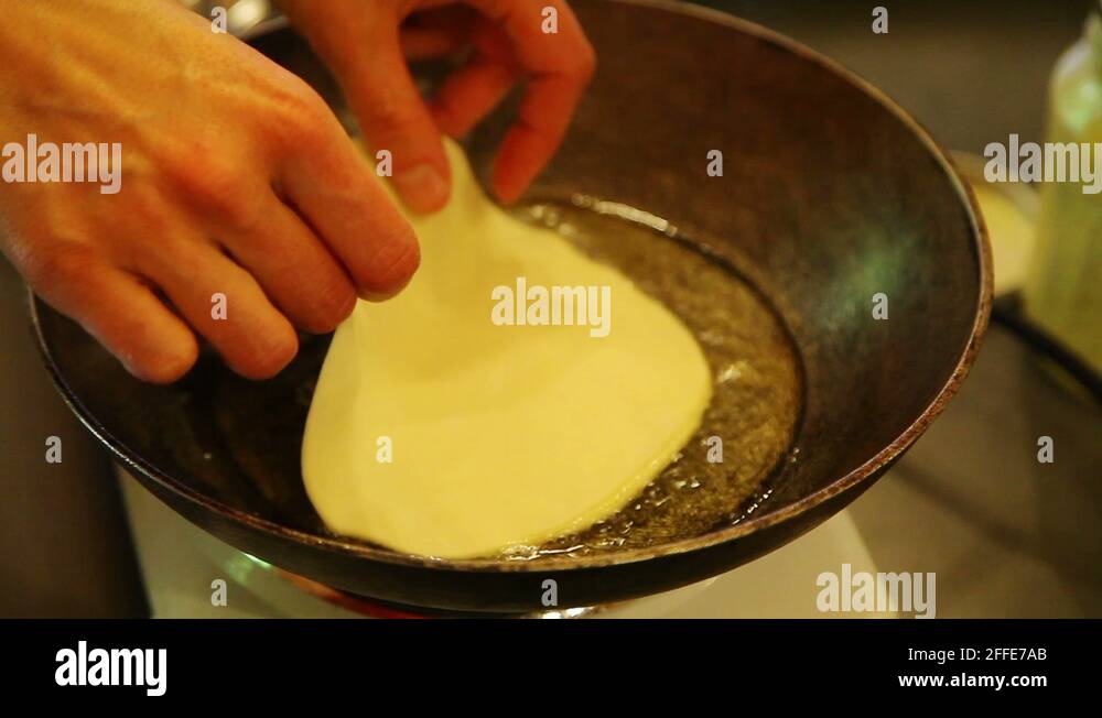 placing chapati on frying pan Stock Video Footage - Alamy