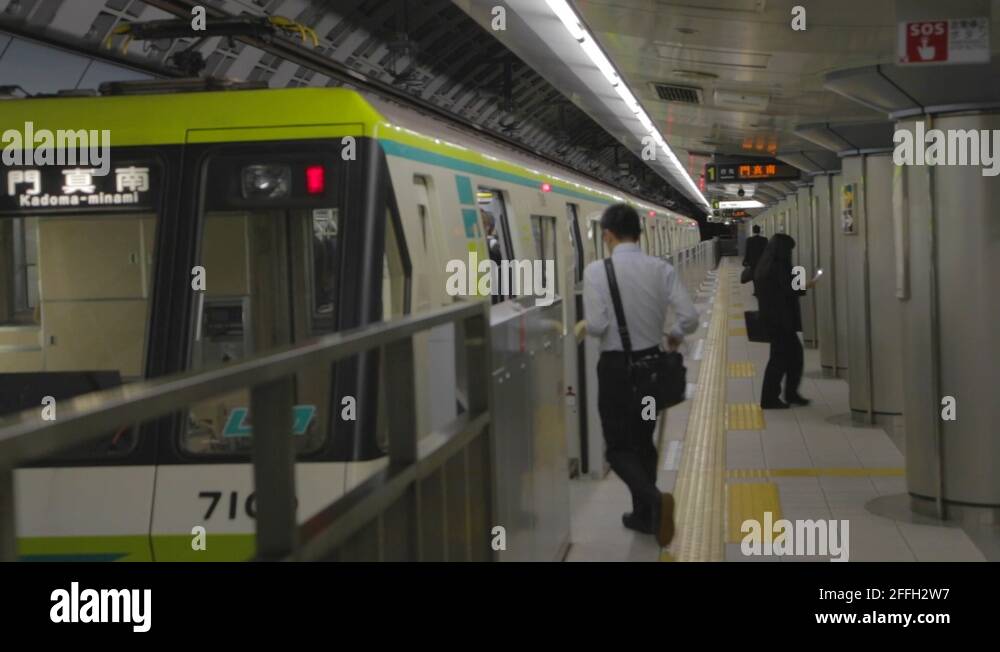 people catching train and train departing at Osaka business park Stock ...