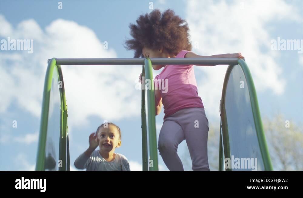 Two young children playing on a slide in slow motion Stock Video ...
