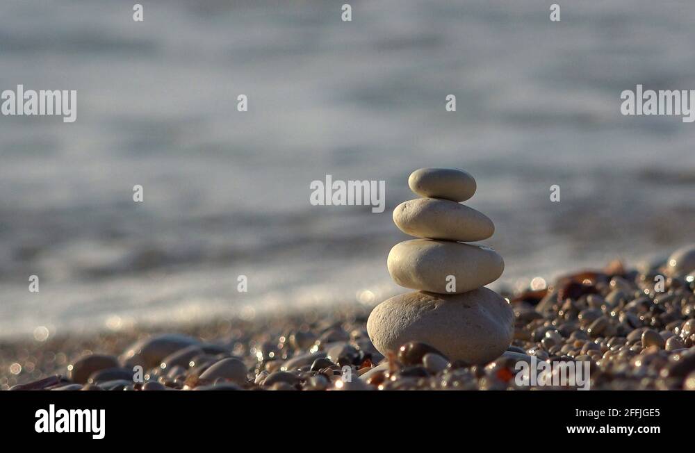 Sea wave on the beach breaking down building of overlapped stone ...