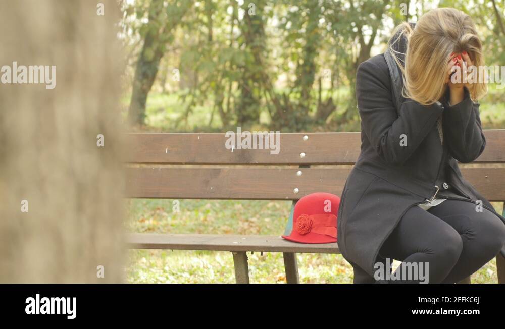 desperate woman sitting on a bench outdoor crying steady cam uhd 4k ...