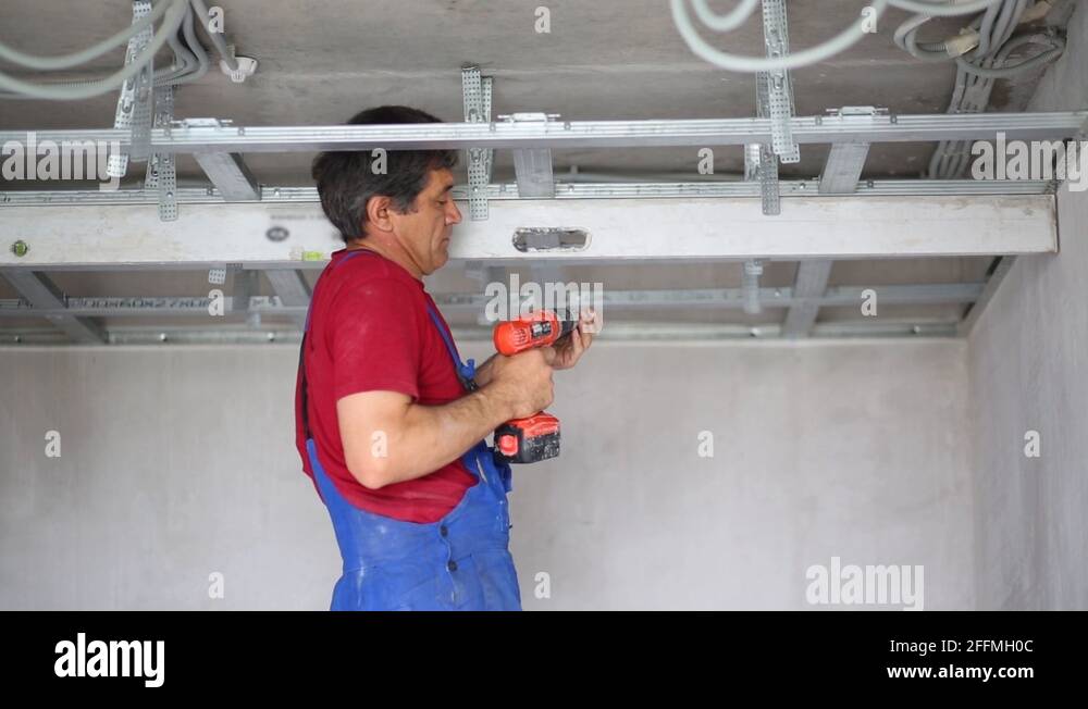 Man install metal framework for hung ceiling by screwdriver Stock Video ...