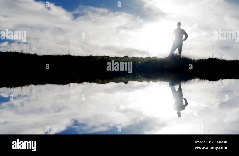 mirror water reflection of man walking outdoors. silhouette person ...