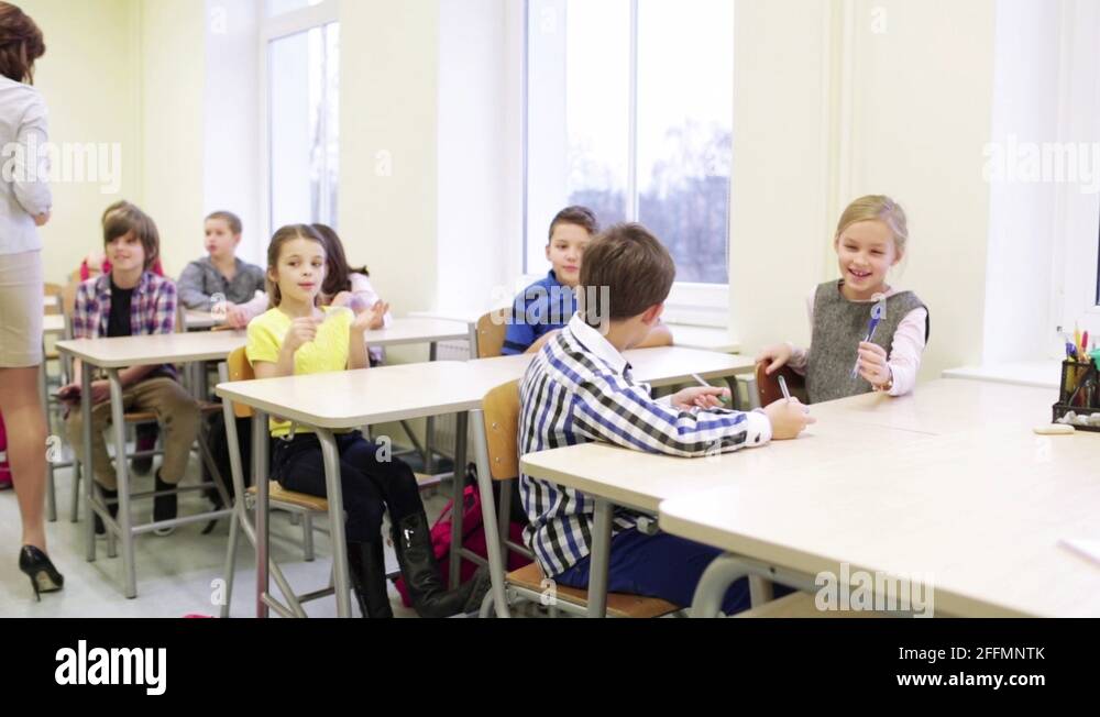 teacher giving pens to school kids in classroom Stock Video Footage - Alamy