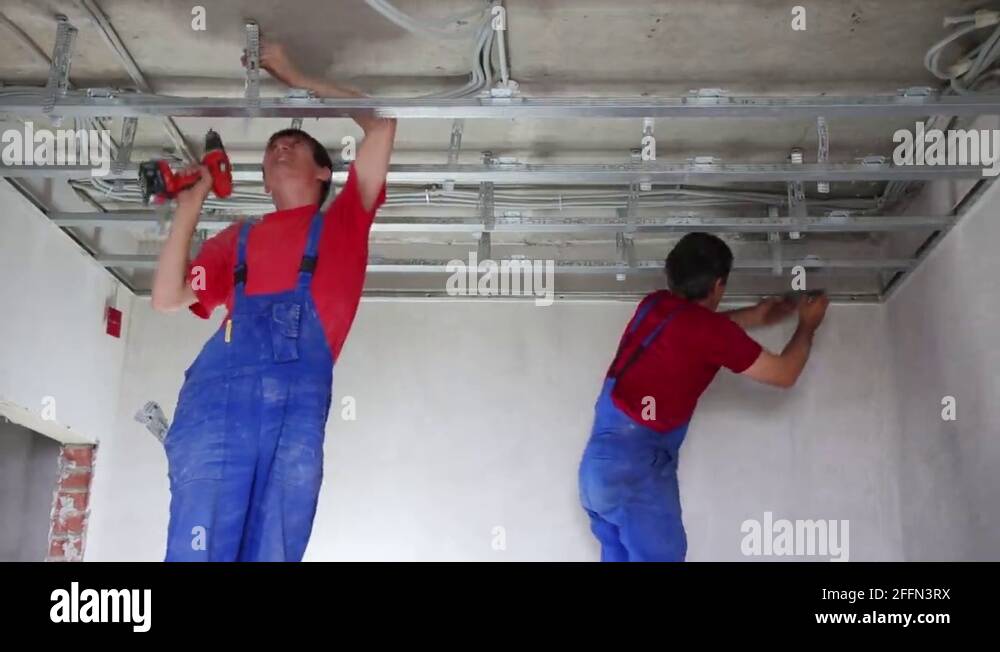 Two men in uniform install framework for hung ceiling Stock Video ...