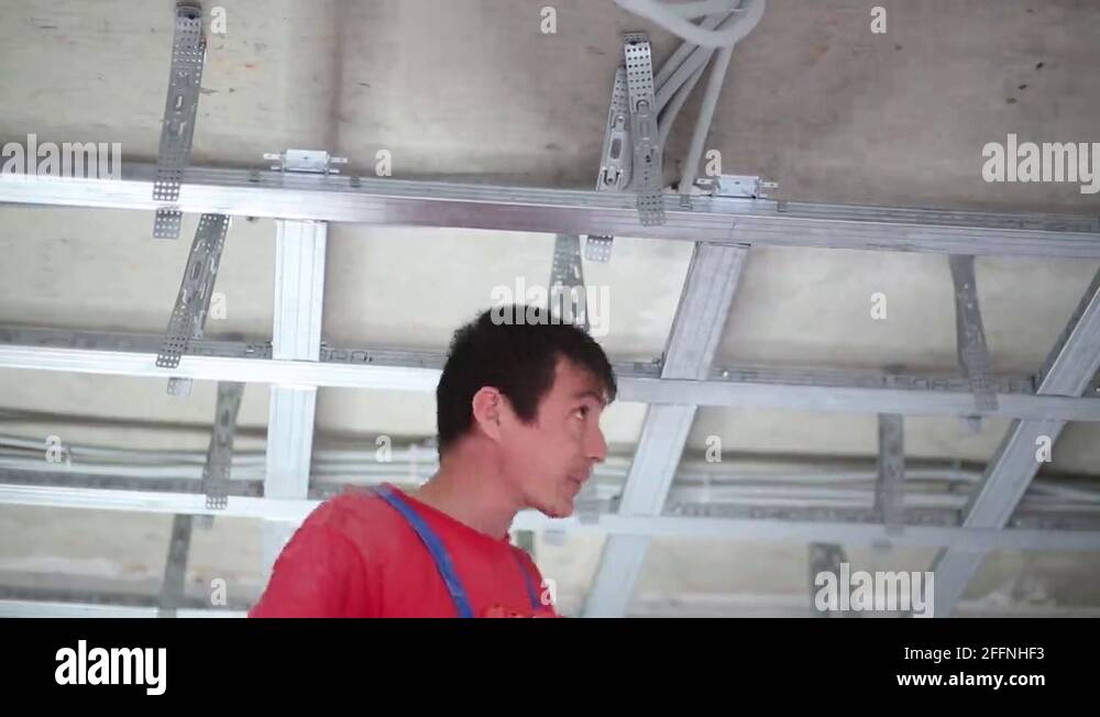 man in uniform install framework for hung ceiling by screwdriver Stock ...