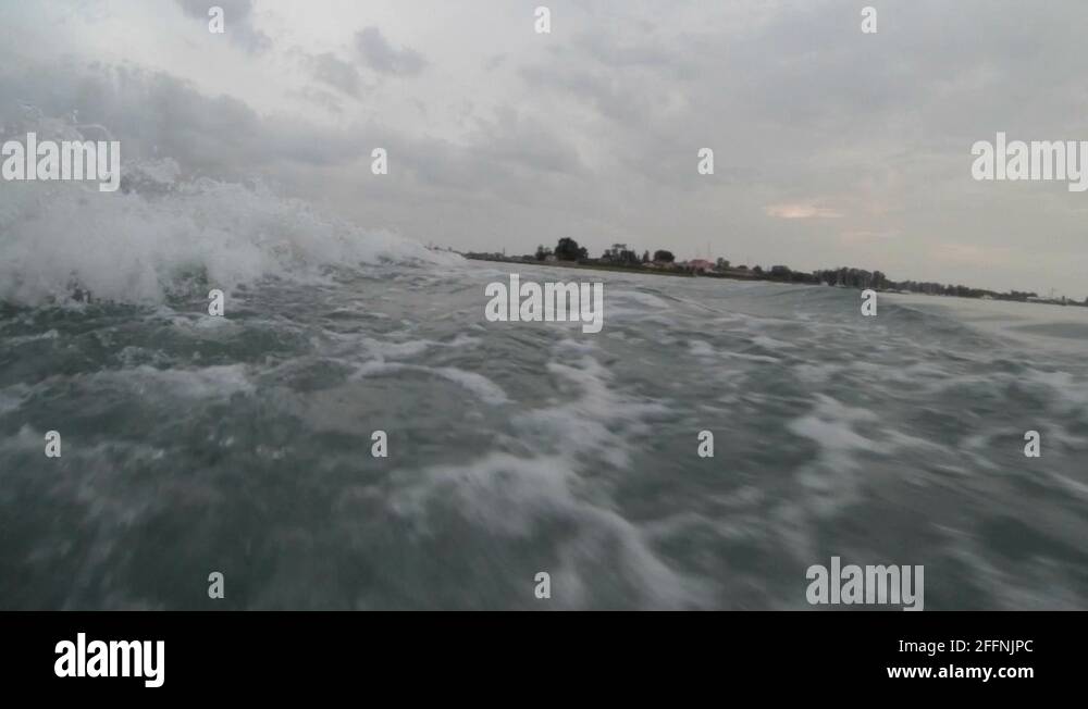 Climate change vulnerability to sea level rise - wave with town in ...