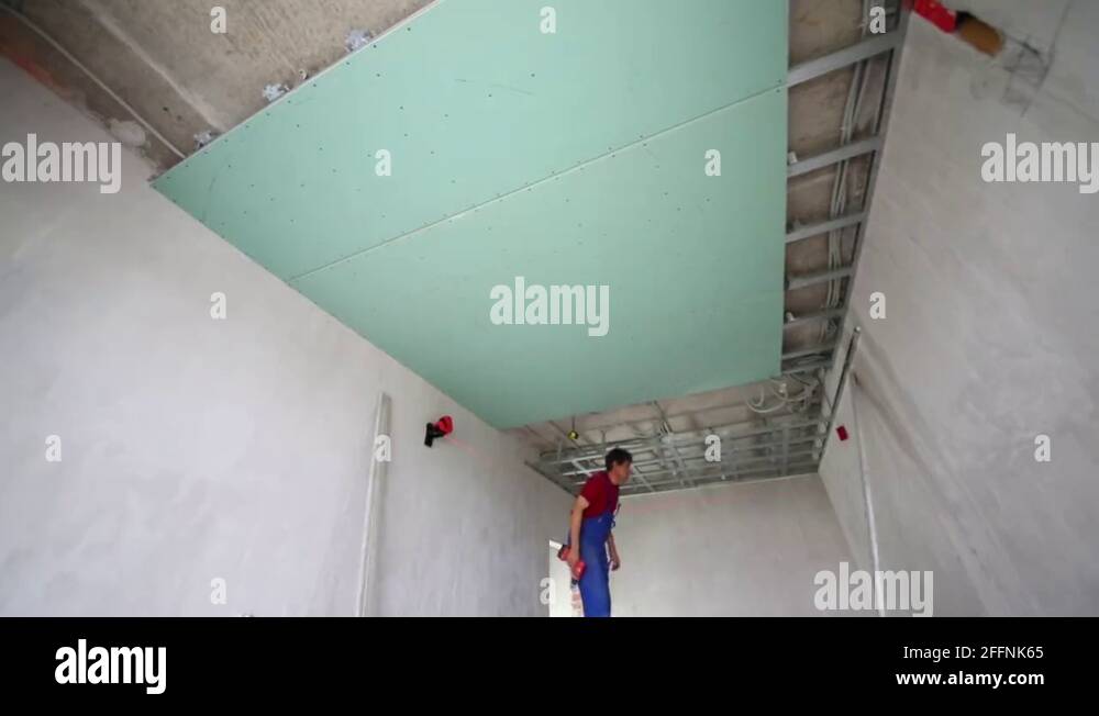 Men verify accuracy of installation frame for hung ceiling Stock Video ...