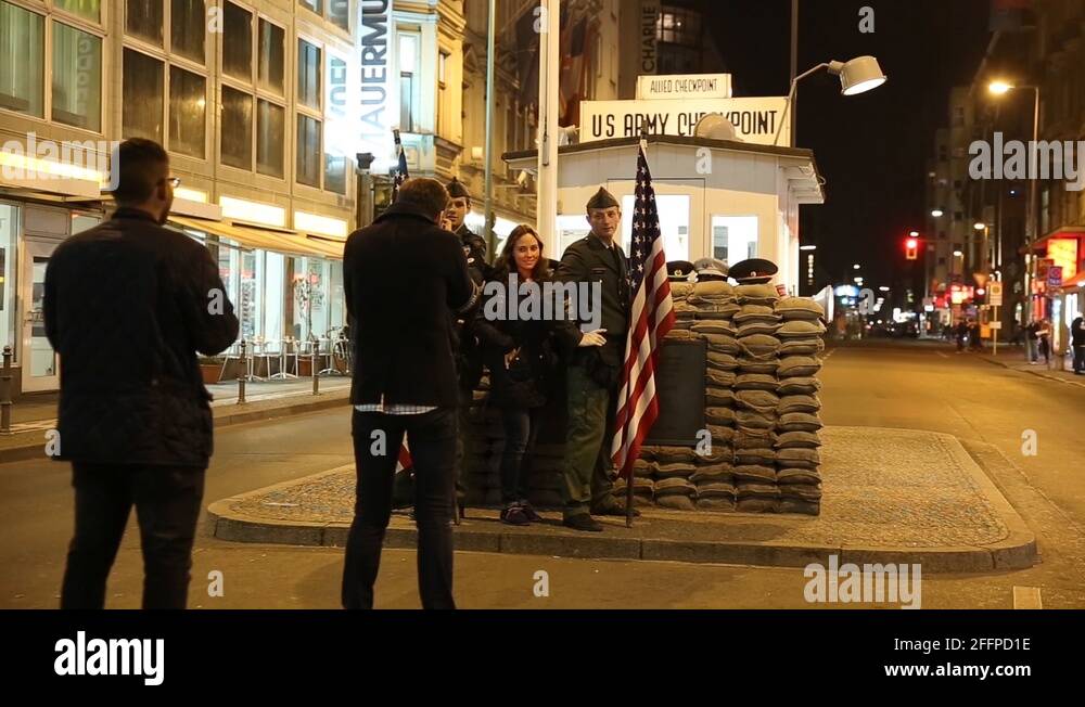 Tourist posing for picture with soldiers at Checkpoint Charlie Stock ...