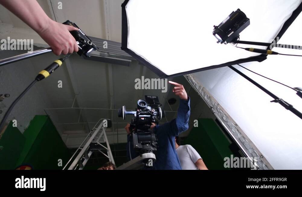 Camera and cameraman and male hands moving lights in studio Stock Video ...