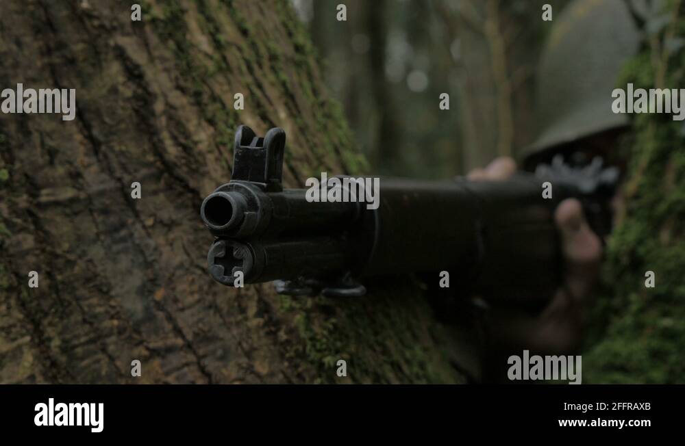 WW2 American infantry soldier aims Grand rifle behinde tree Stock Video ...