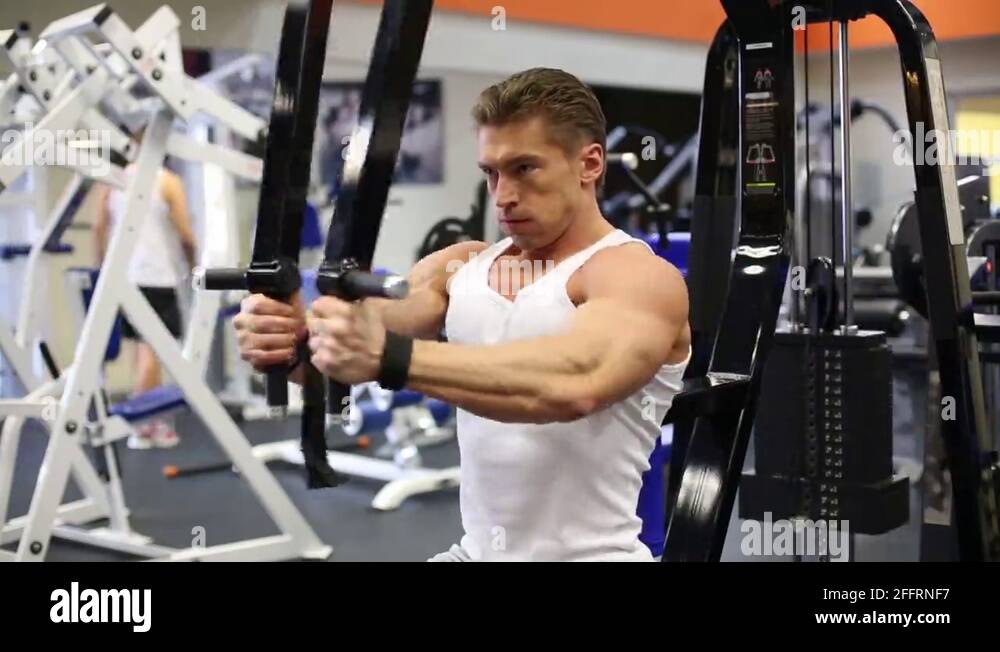 Brown hair man bodybuilder does shoulders exercises in gym hall Stock Video Footage - Alamy