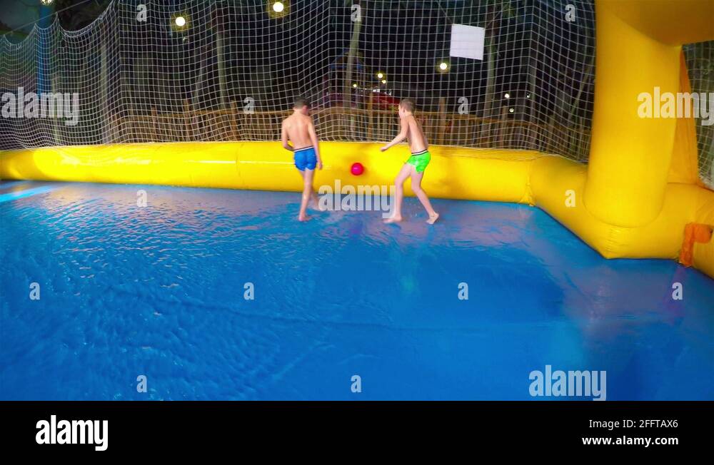 Tow teen fun boys play in football on water surface. Water falls and ...