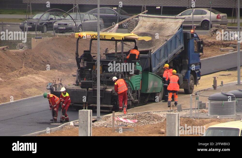 Asphalt spread equipment and truck. Road construction workers Stock ...